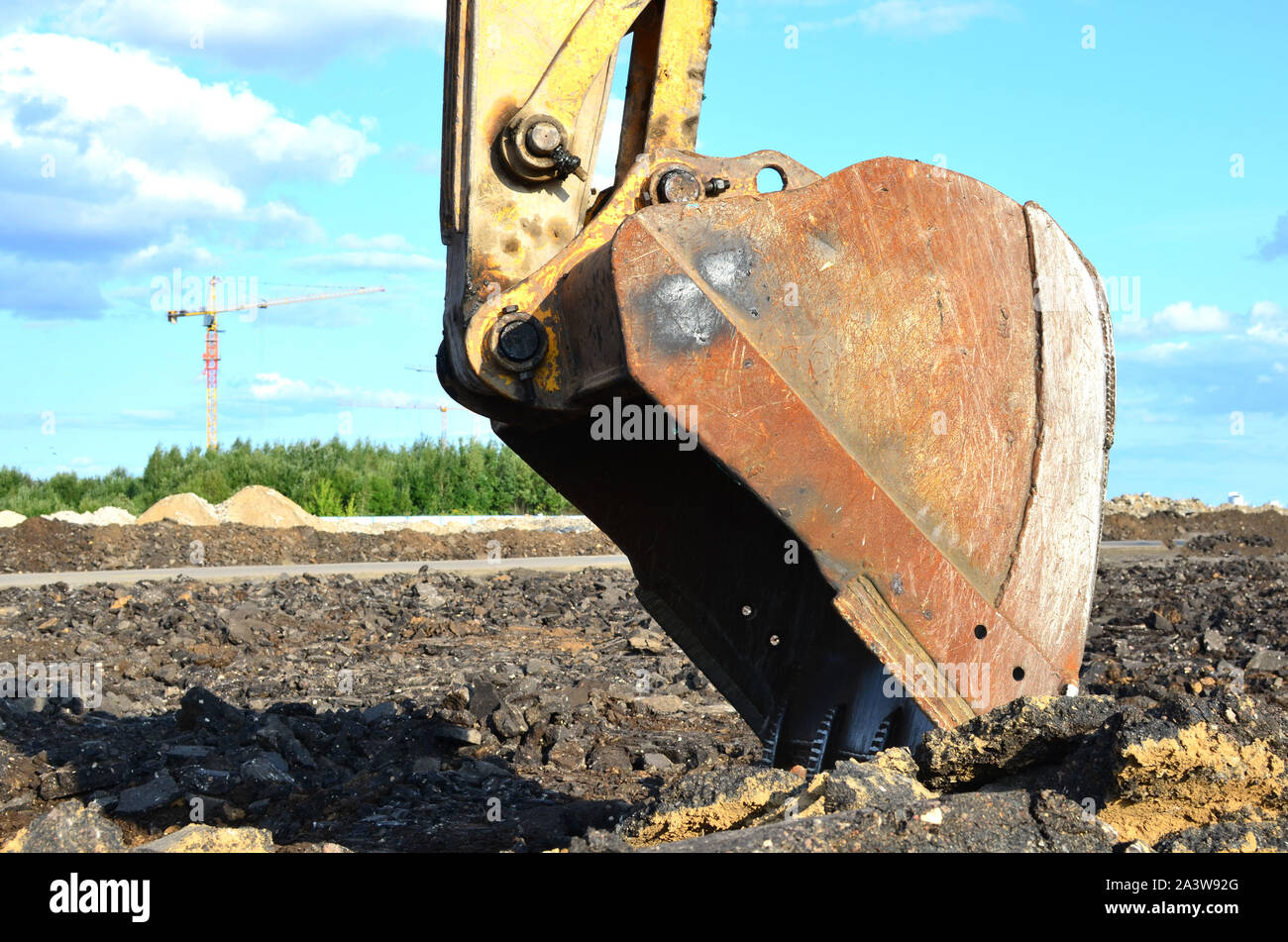 Excavator working in a construction site. Large metal iron ladle ...