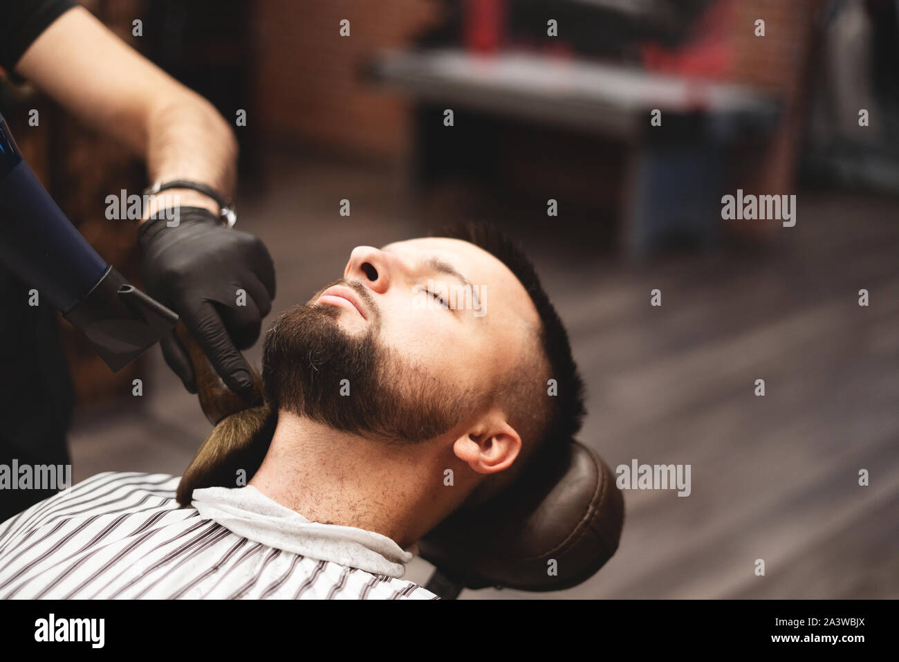 Shaving a beard in a barbershop with a dangerous razor. Barber Shop ...
