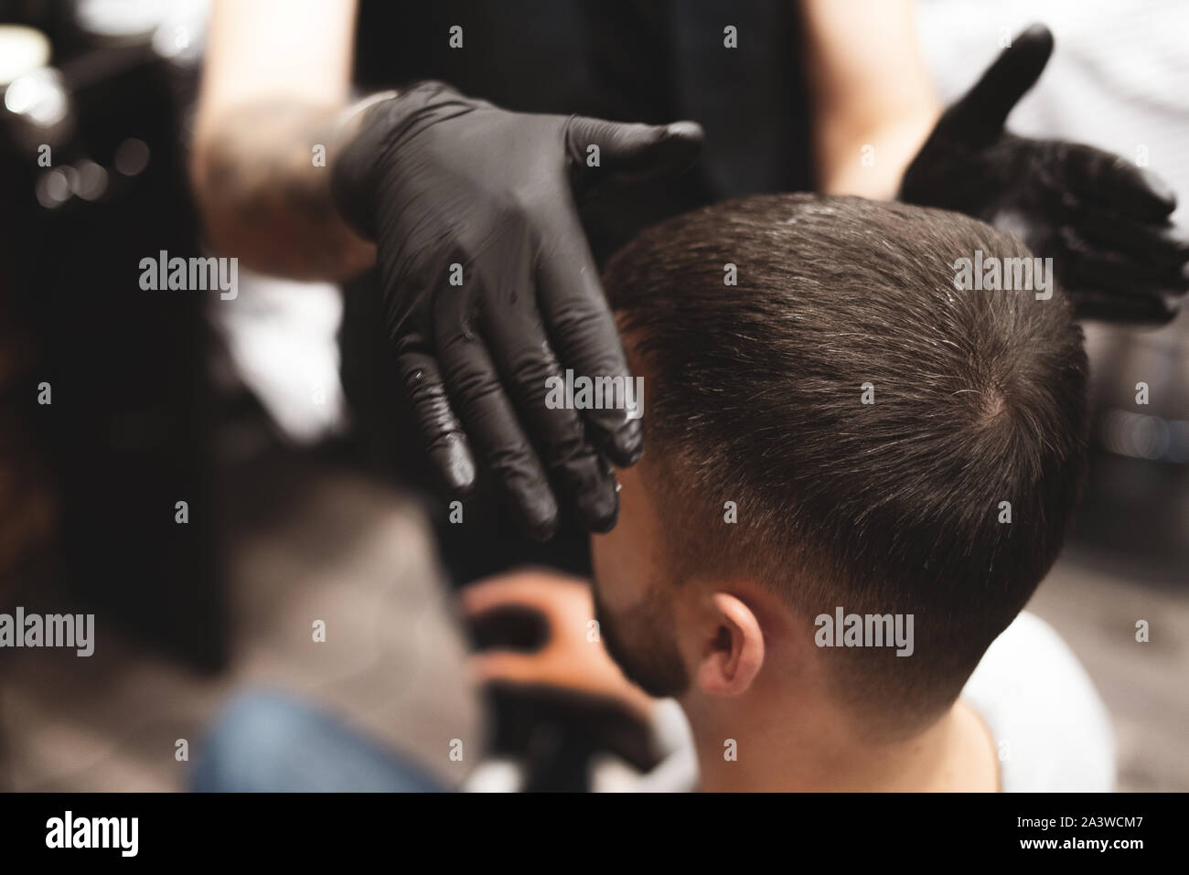 Haircut head in barbershop. Barber cuts the hair on the head of the ...