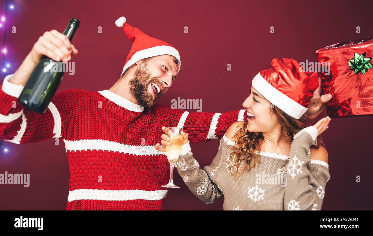 Happy couple drinking champagne at christmas time - Young people having ...