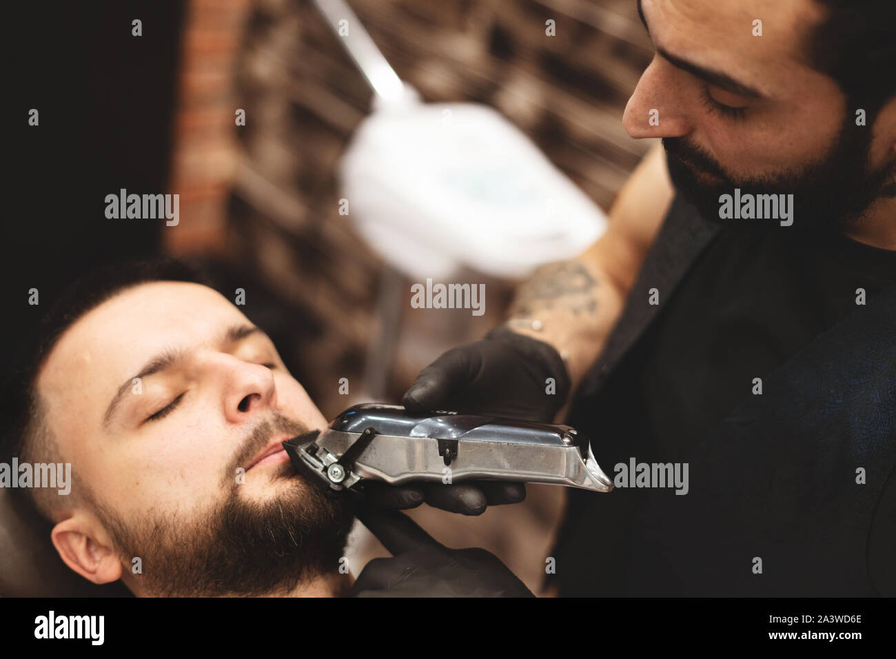 Shaving a beard in a barbershop with a dangerous razor. Barber Shop ...