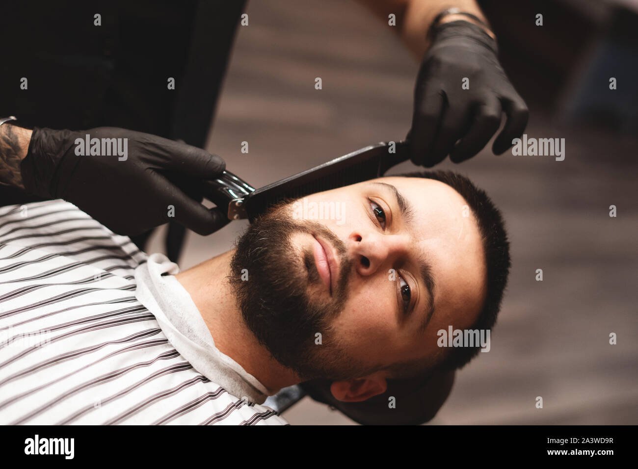 Shaving a beard in a barbershop with a dangerous razor. Barber Shop ...