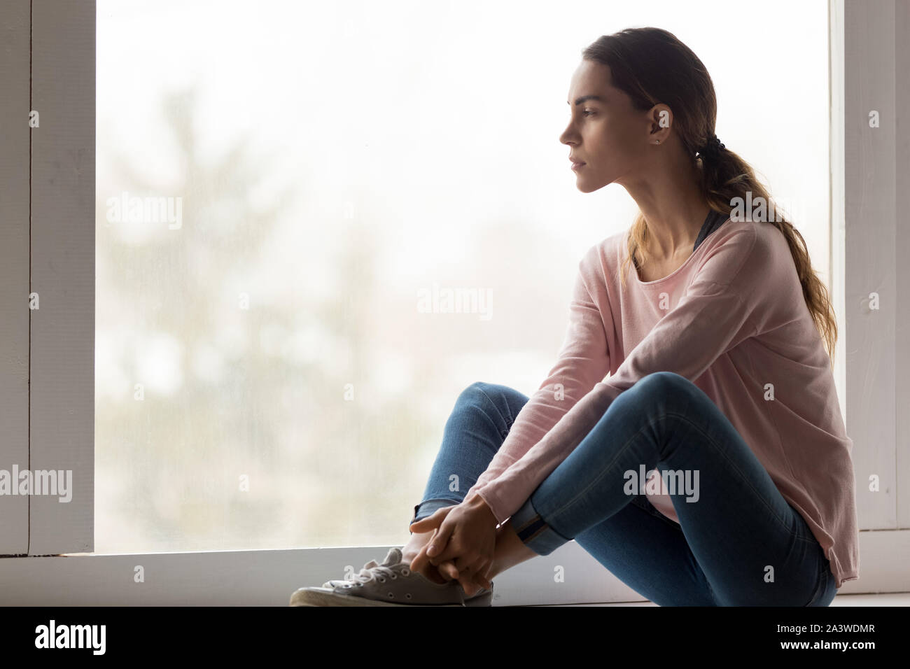 Sad pensive thoughtful girl sit on sill looking through window Stock ...