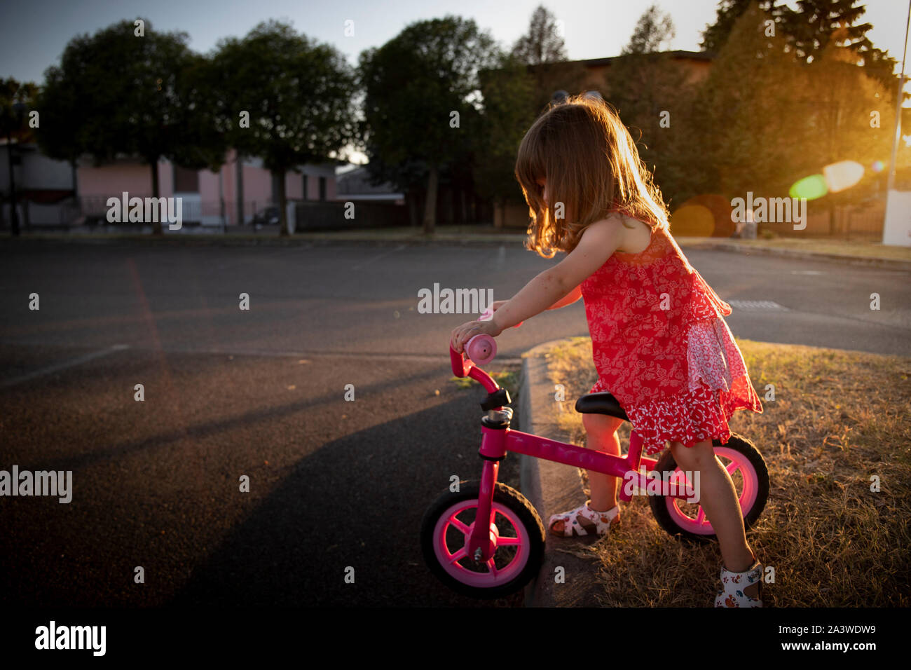 Toddler child girl riding her dynamic bycicle in urban outdoor location ...