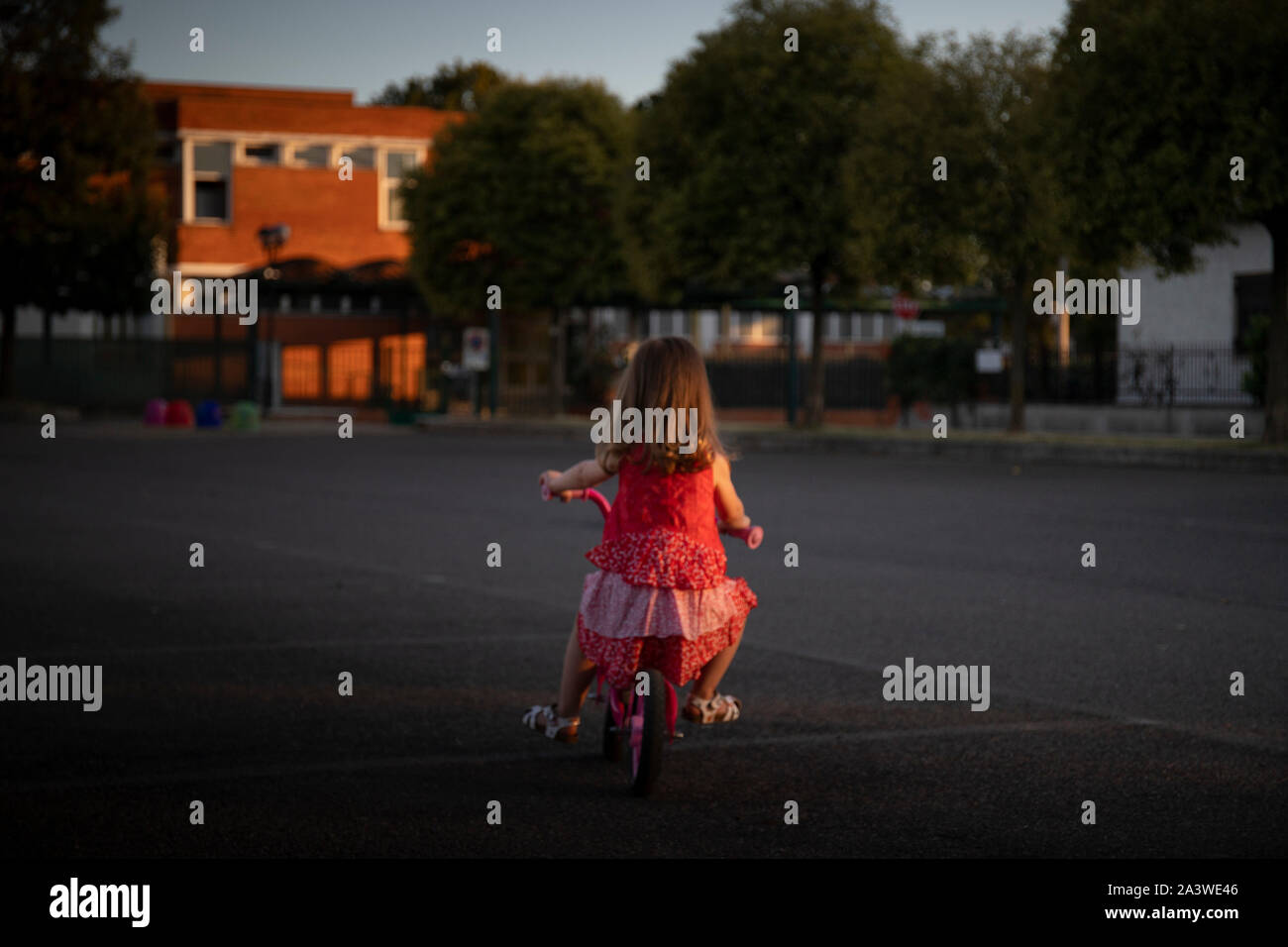Toddler child girl riding her dynamic bycicle in urban outdoor location ...