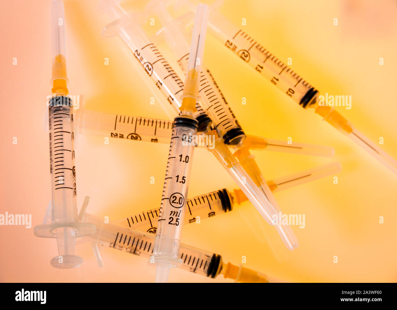 Group of syringes on orange background Stock Photo - Alamy