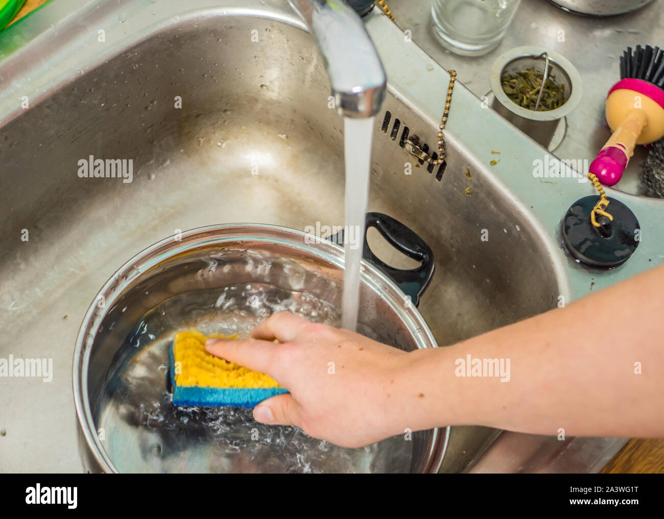 Woman wastes water washing dishes Stock Photo - Alamy