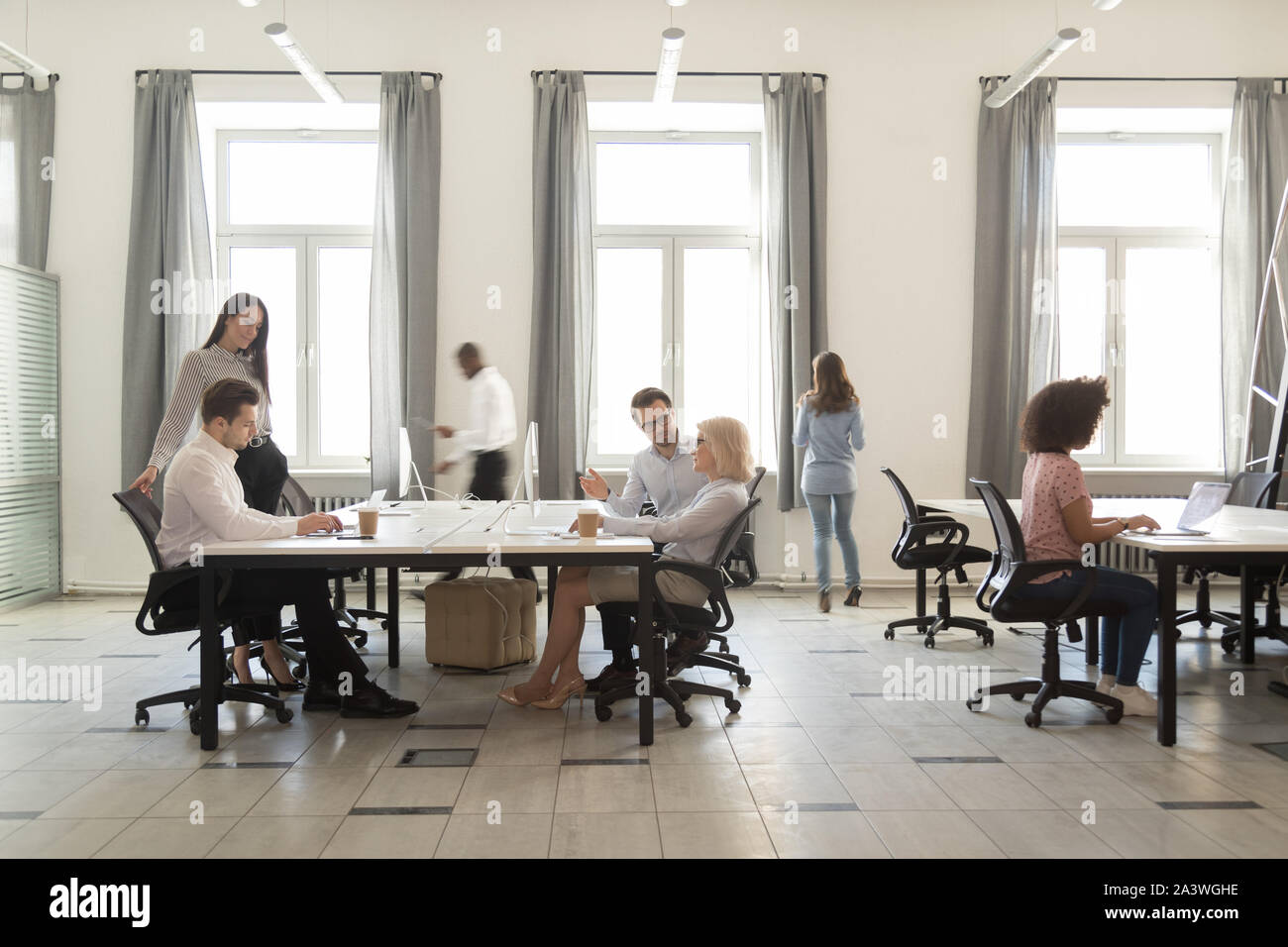 Busy diverse employees working in modern office coworking room Stock ...
