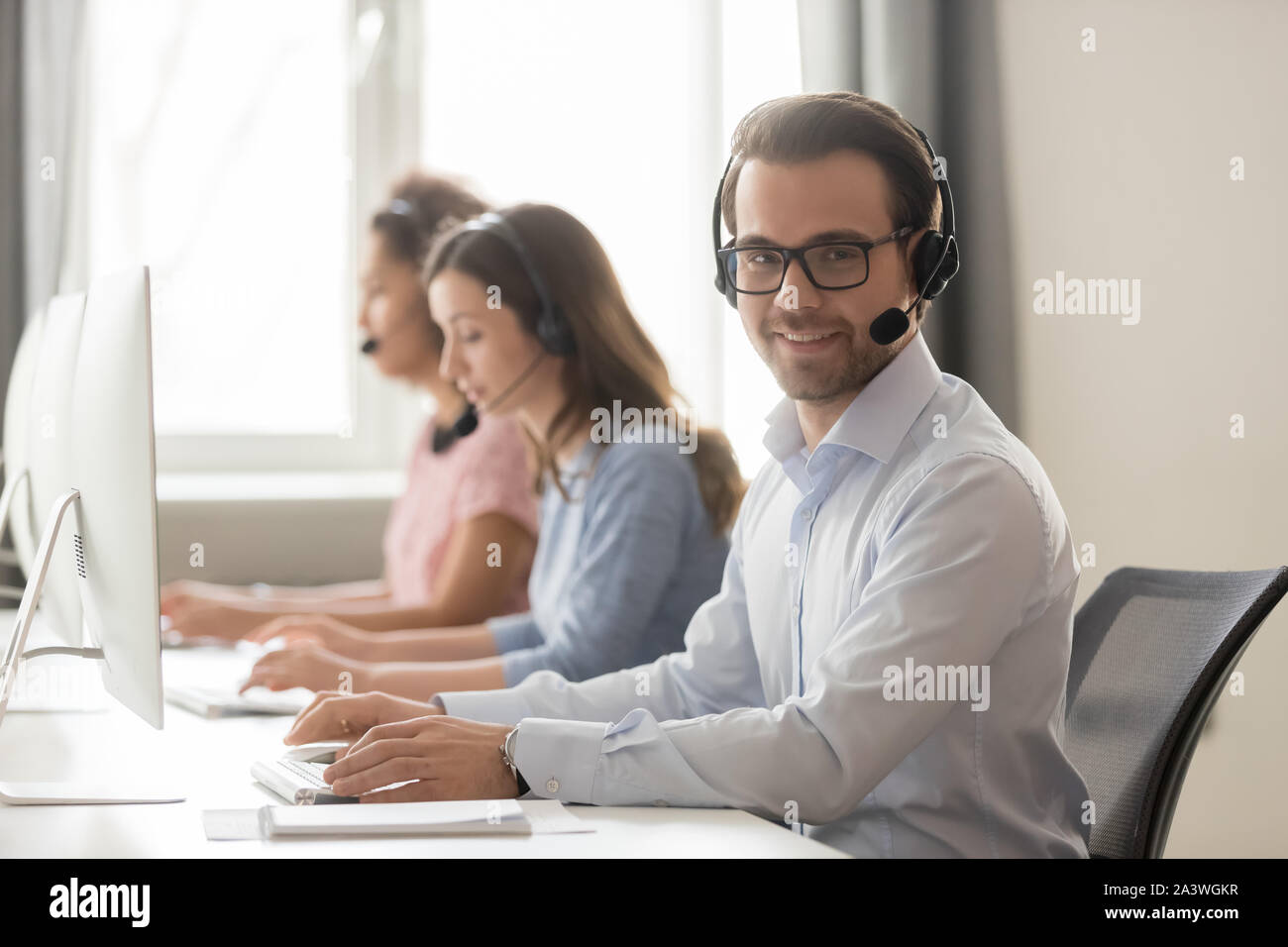 smiling call center employee sitting at his Desk Stock Photo - Alamy