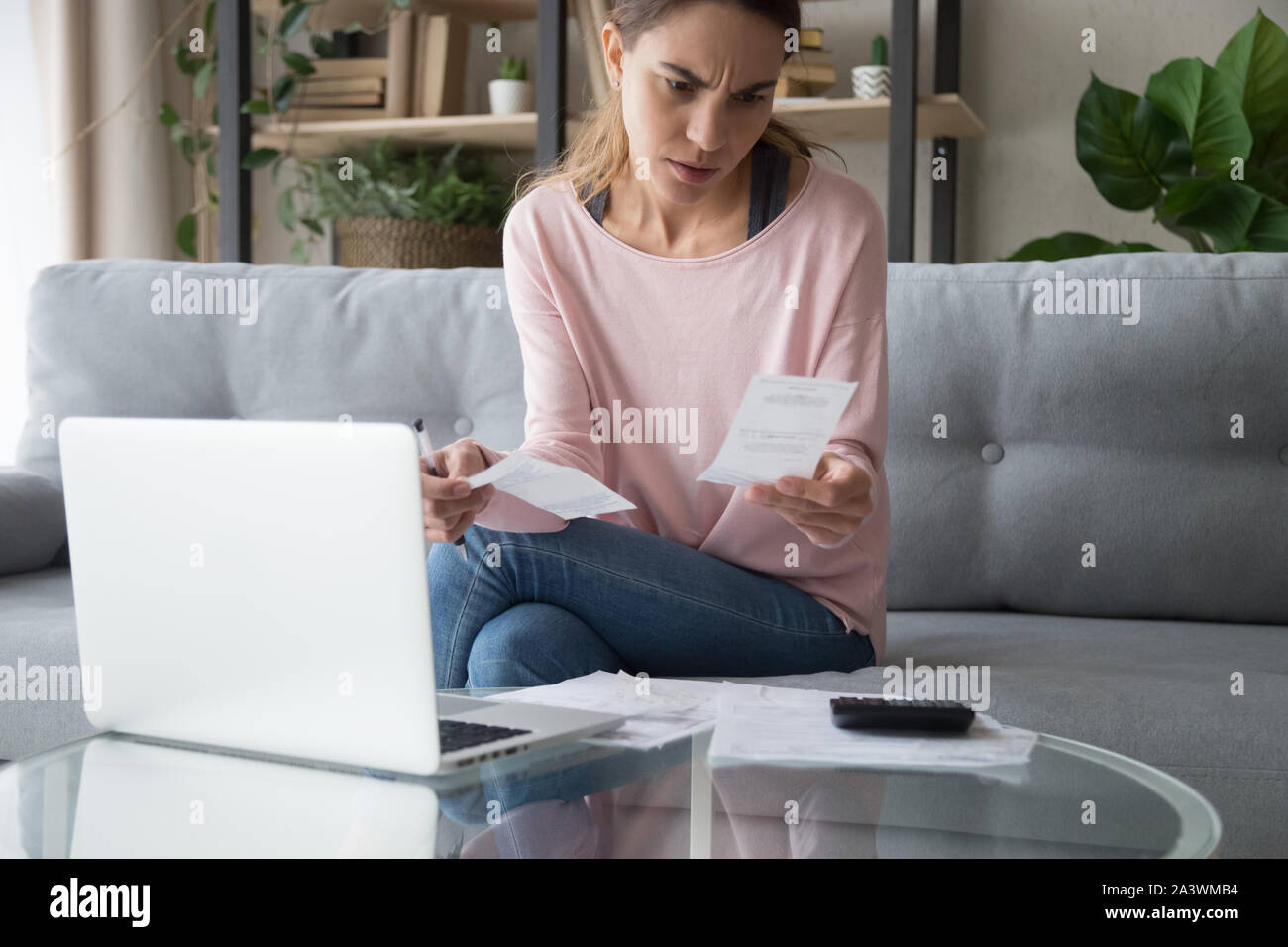 Stressed young woman hold papers calculate bills worried about debt ...