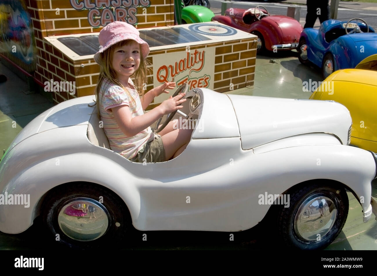 Girl on a merry-go-round car at a fair Stock Photo - Alamy
