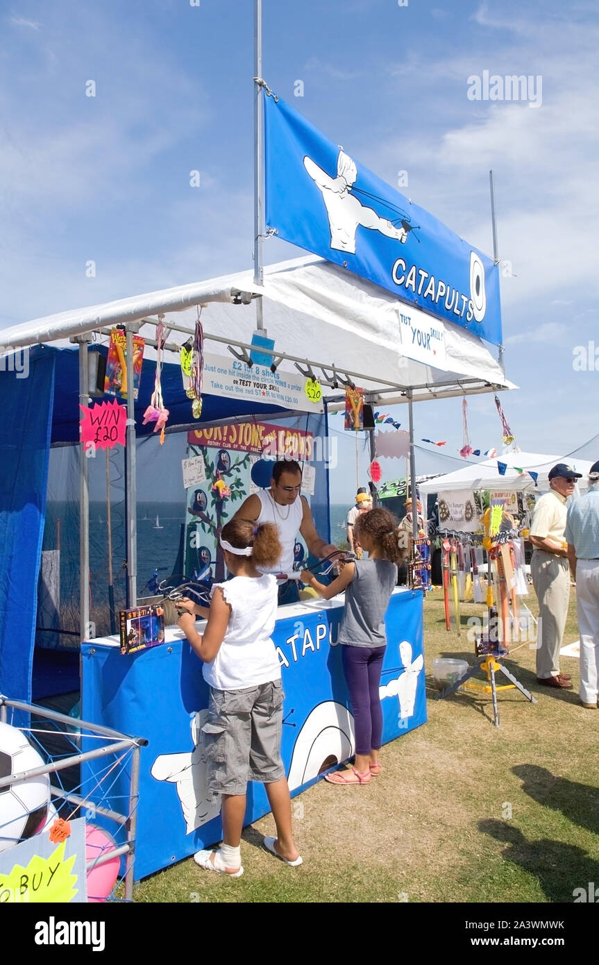 Two girls playing a Catapult game a a fair Stock Photo - Alamy