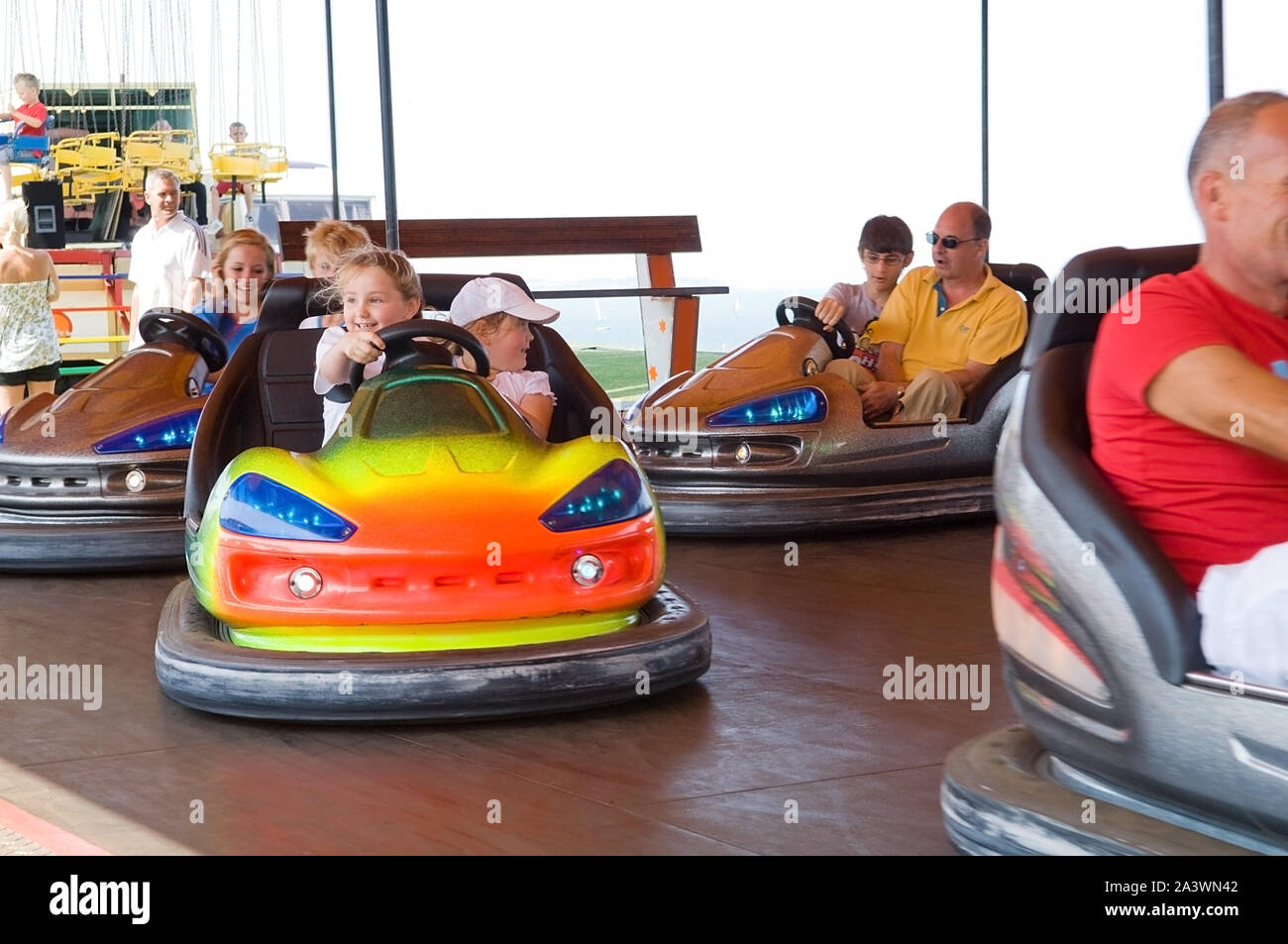 People on the dodgems at a fair showing the people having fun and ...