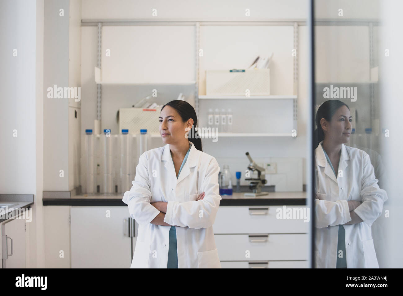Female scientist looking out of window with reflection Stock Photo - Alamy