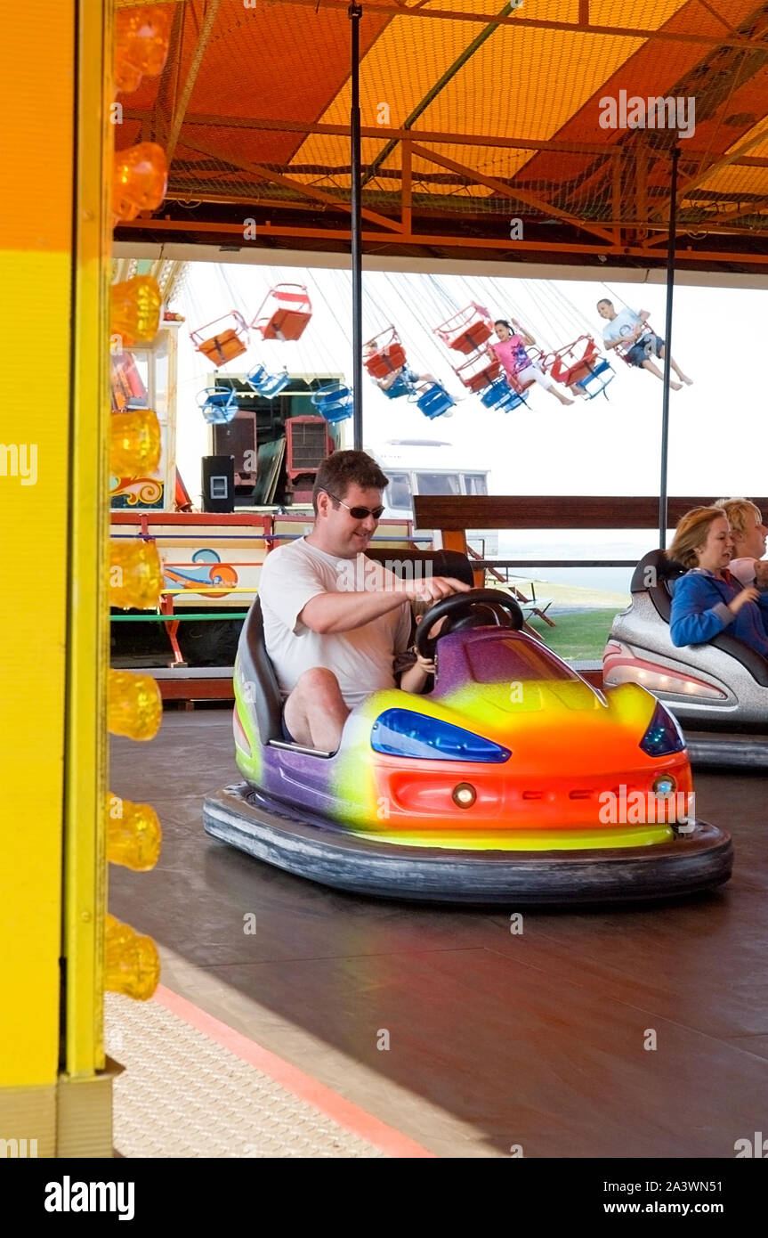 People on the dodgems at a fair showing the people having fun and ...