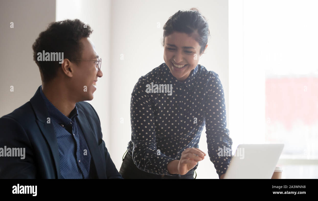 Happy diverse coworkers team laughing talking at office work Stock ...