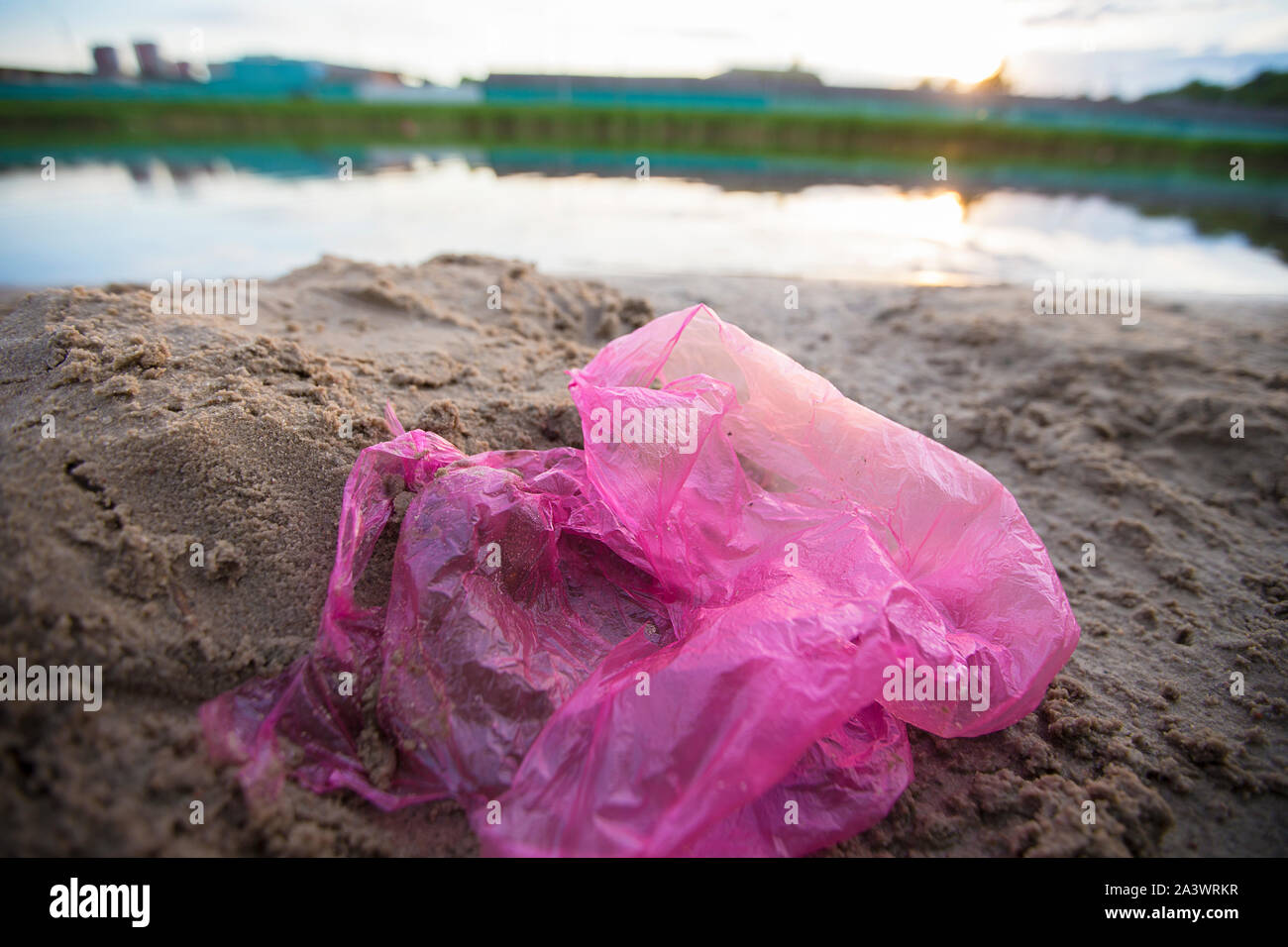 Cellophane package on the river bank. Environmental pollution.Garbage ...