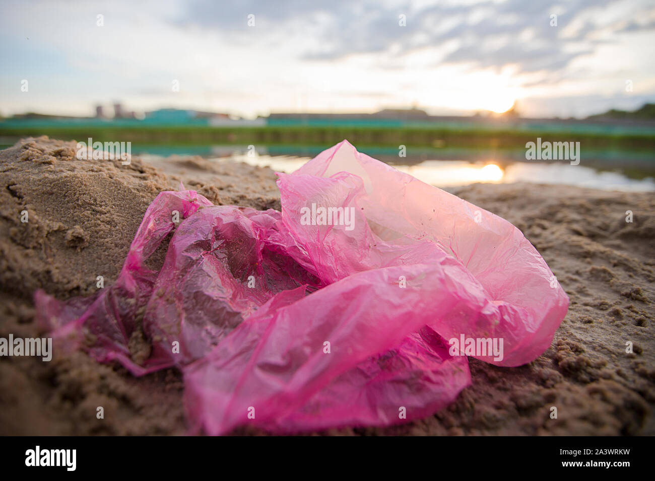 Cellophane package on the river bank. Environmental pollution.Garbage ...