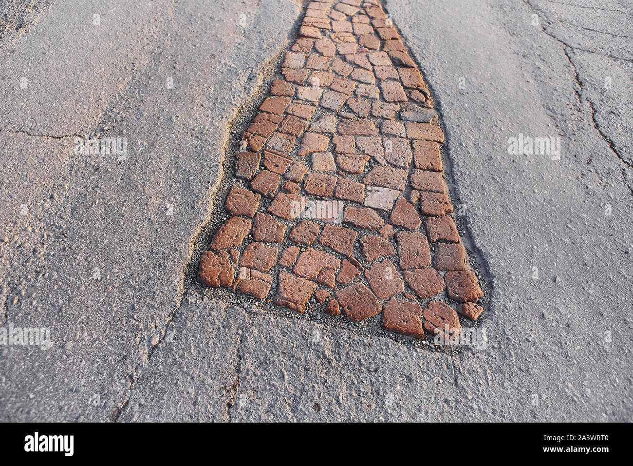 potholes in the road sealed with old bricks. Creative way to repair ...