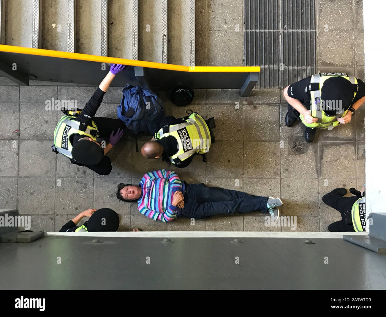 A climate change protester in the DLR underpass surrounded by police ...