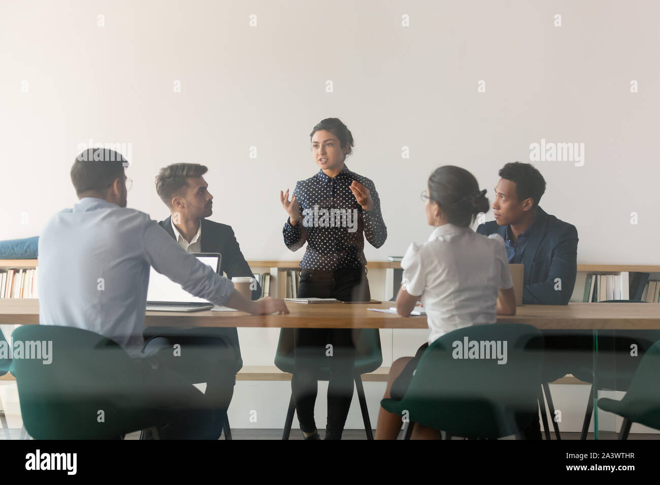 Serious female indian manager talk at group meeting behind glass Stock ...