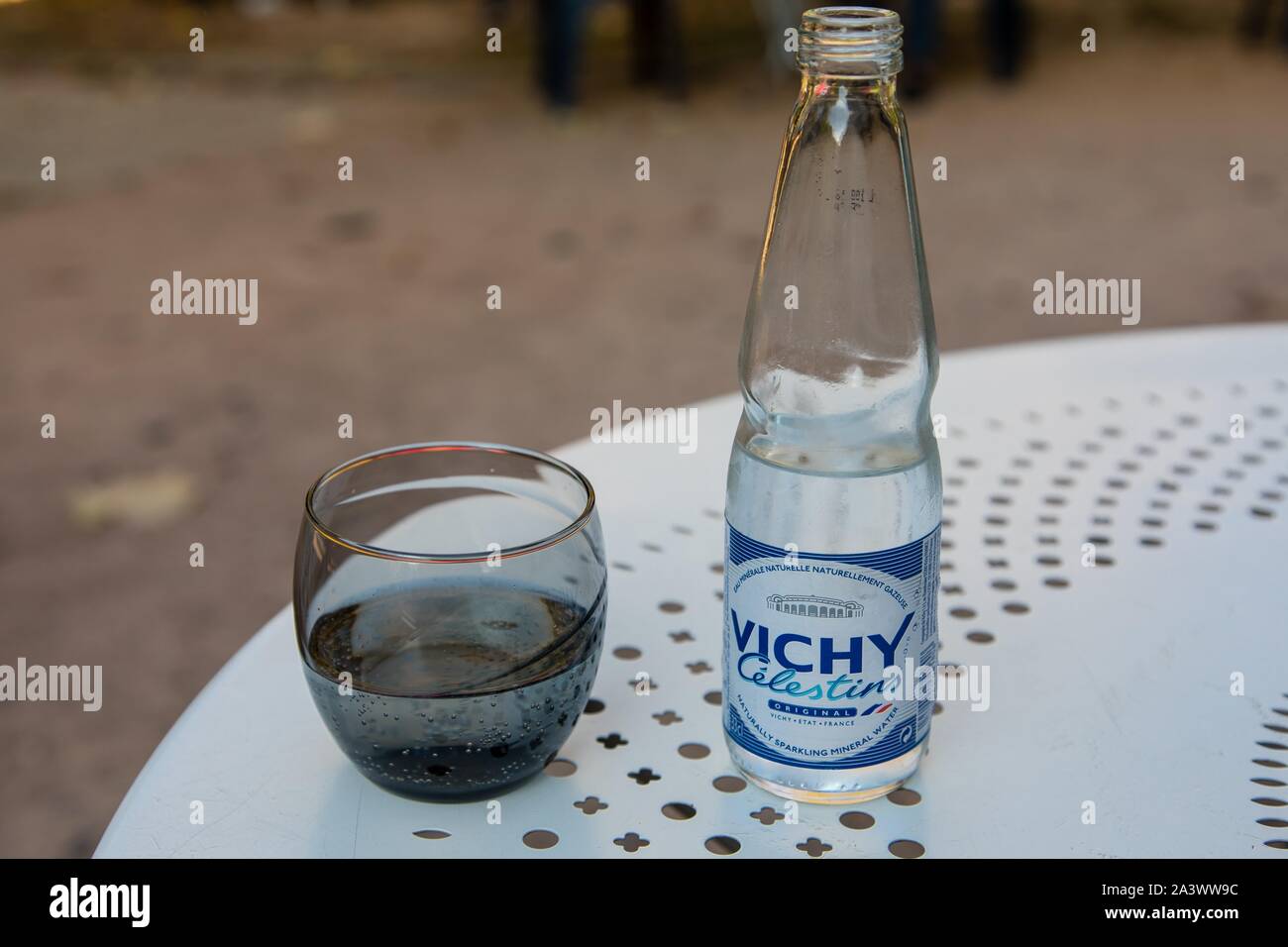GLASS OF WATER AND BOTTLE OF VICHY CELESTINS SERVED ON THE TERRACE OF A ...