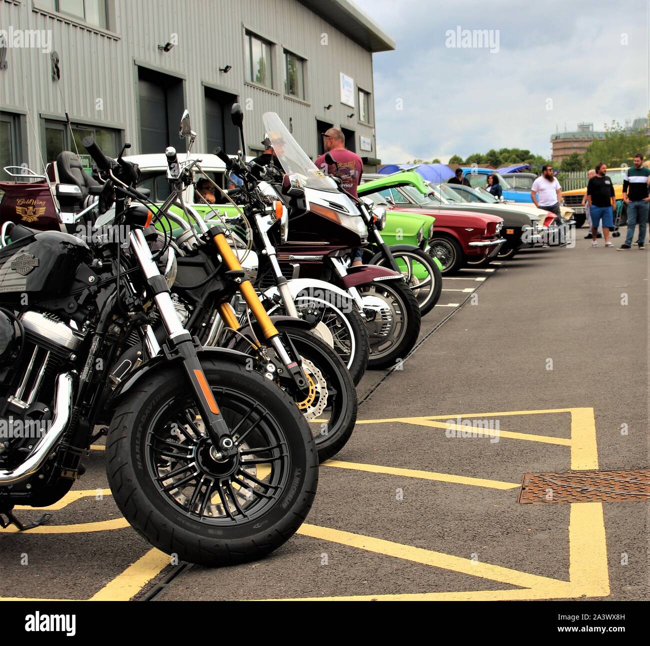 Cars and motorbikes lined up at a meetup with the theme of America ...