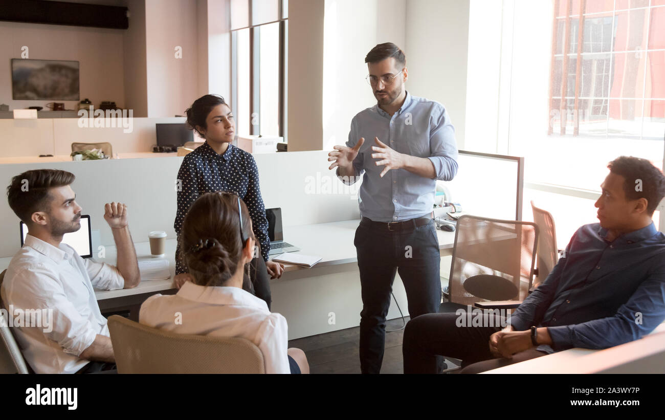 Serious team leader talk to diverse business people at meeting Stock ...