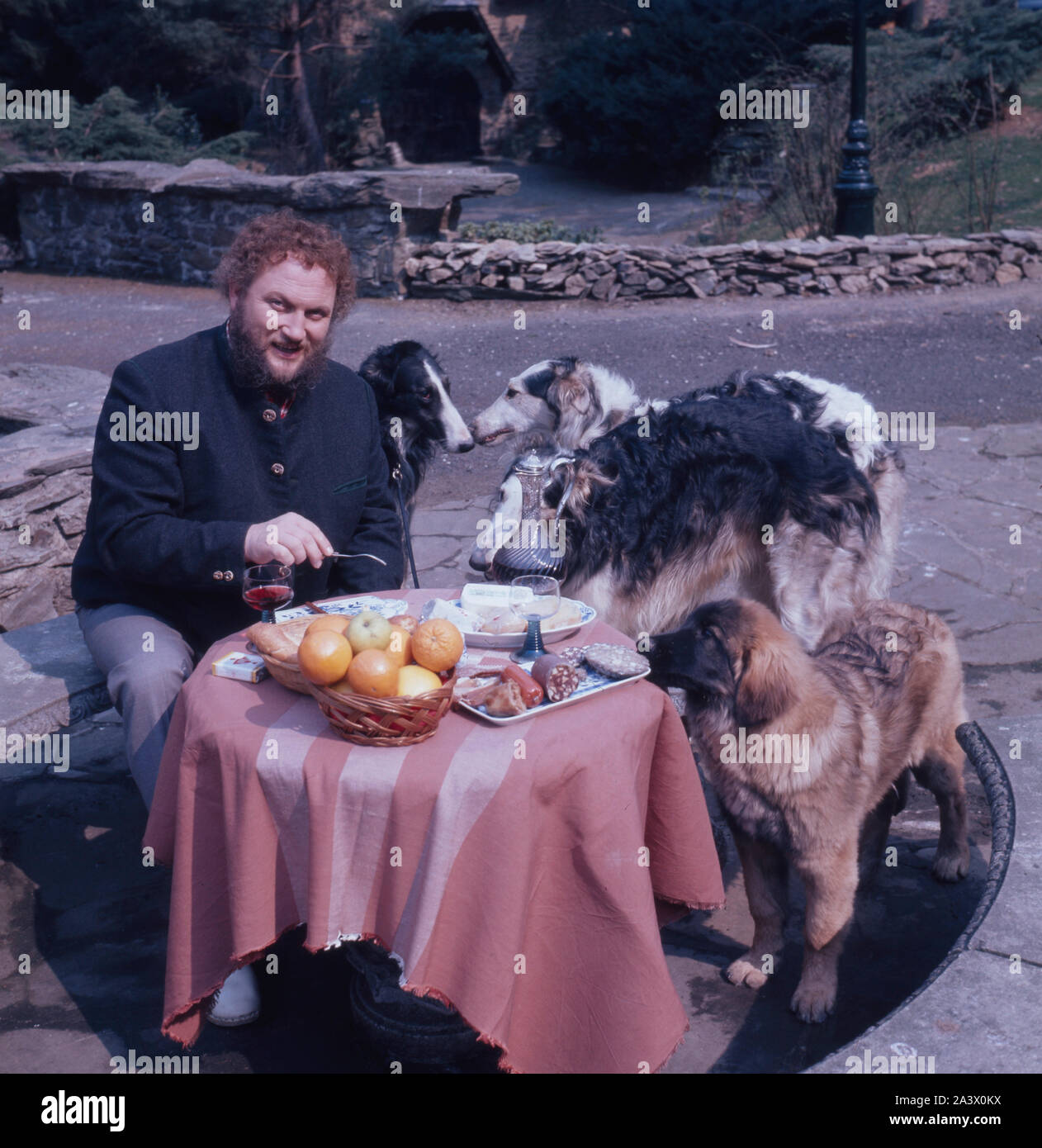 Der deutsche Bass Sänger Ivan Rebroff beim Essen mit seinen Hunden ...
