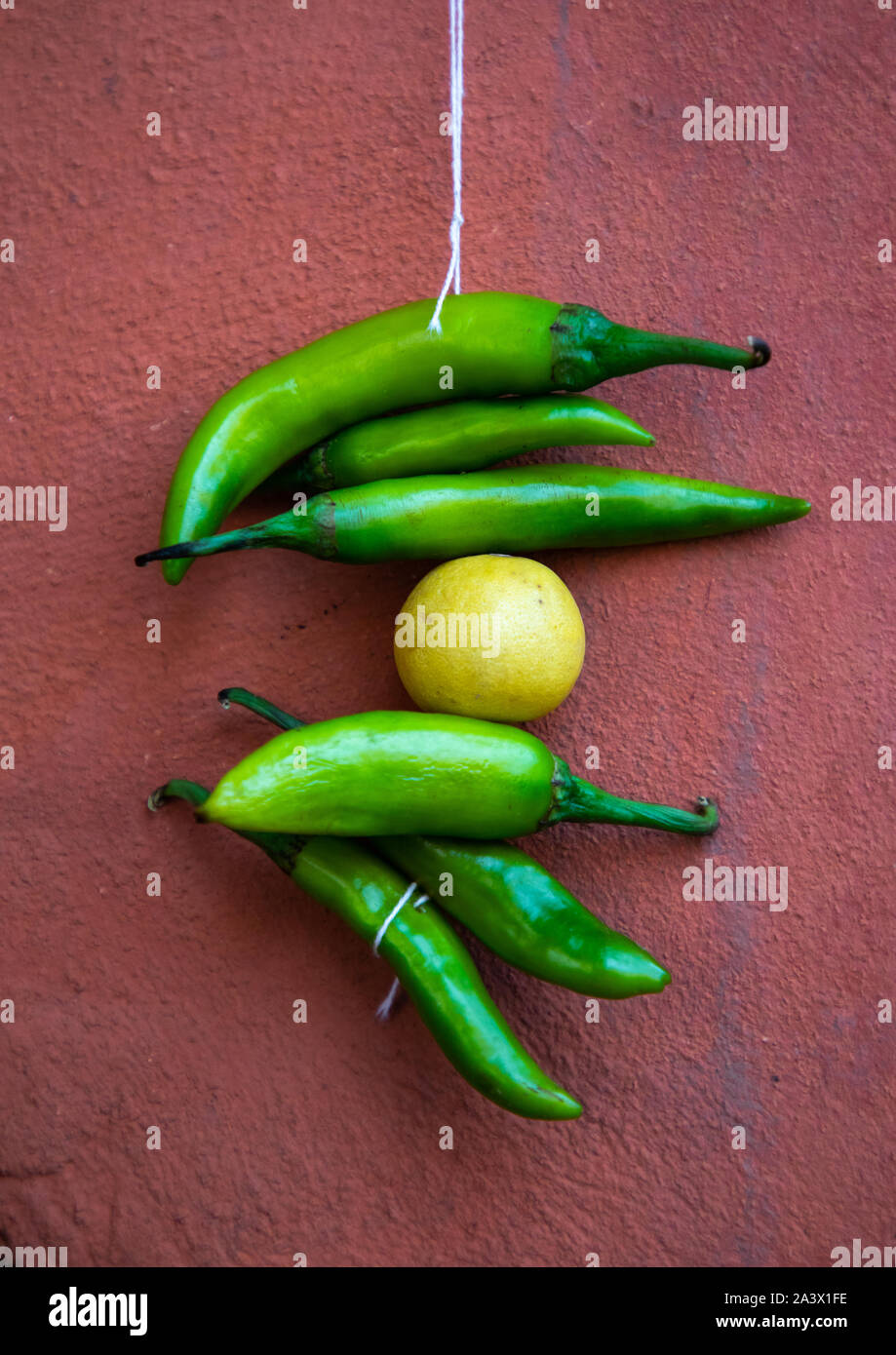 Lemon and green chilli tied on a thread hung outside a door to keep ...