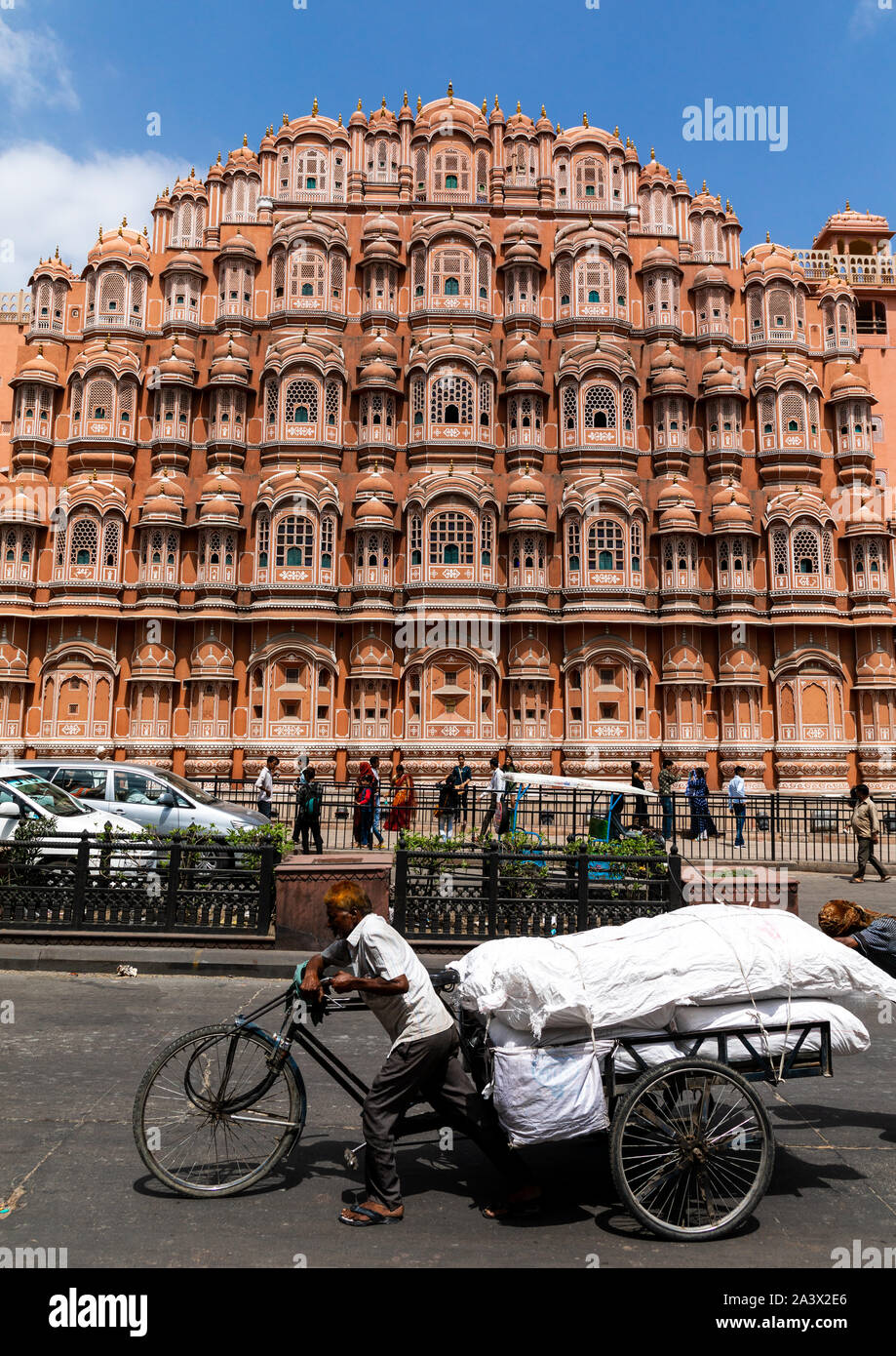 Indian man pushing a loaded bicycle in front of front of the hawa mahal ...