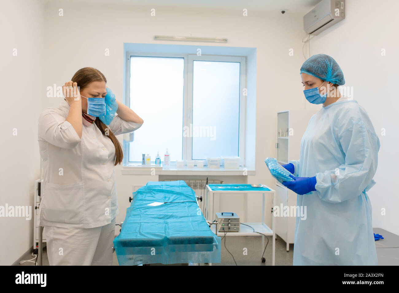 A nurse dresses a surgeon in a sterile suit before surgery Stock Photo ...