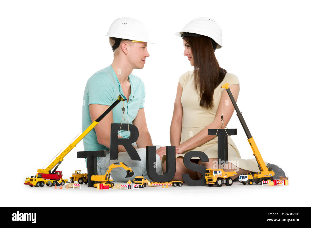 Establishing trust: Young couple with machines building trust-word ... Establishing trust: Young couple with machines building trust-word ...