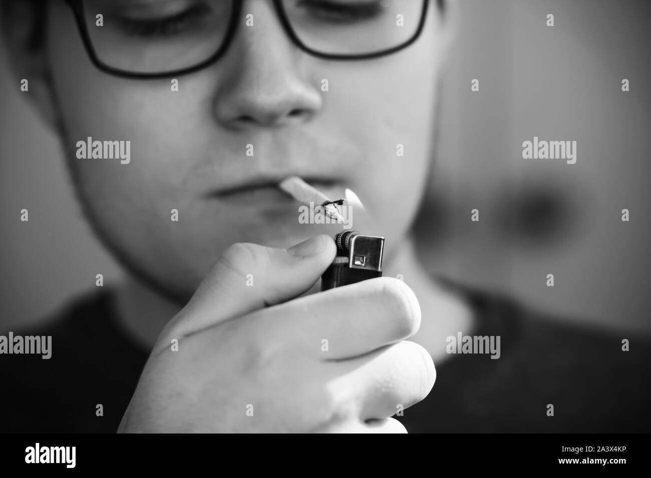 Young man lighting cigarette Black and White Stock Photos & Images - Alamy