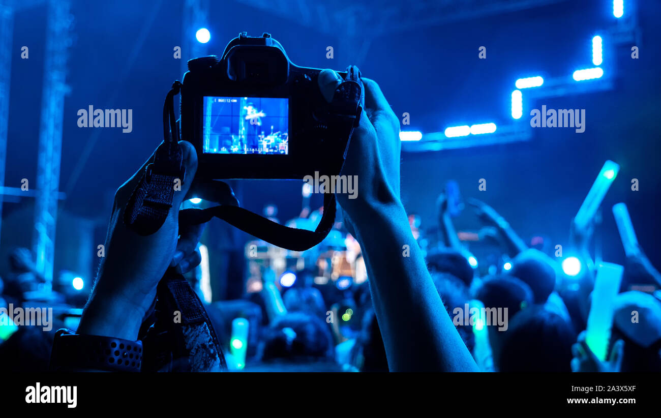 Photographer taking picture with camera at a festival concert with ...