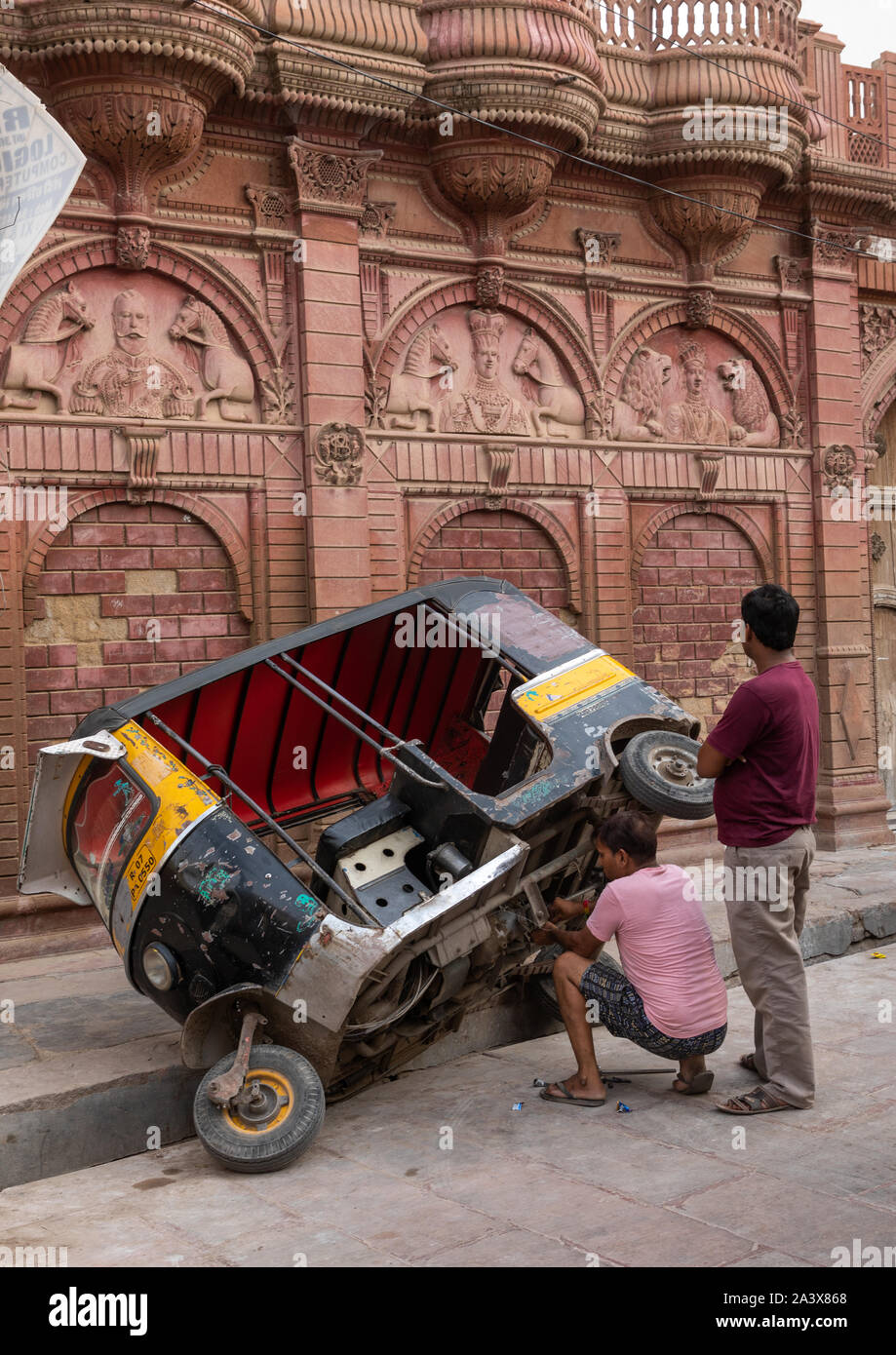 Indian men fixing a rickshaw in the street, Rajasthan, Bikaner, India ...