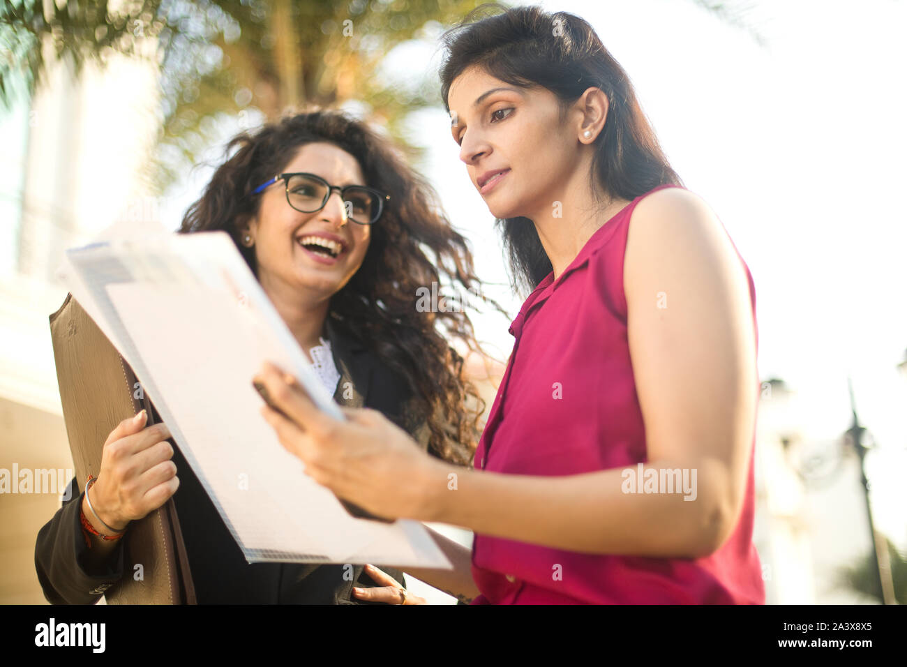 Smiling business people reviewing file hi-res stock photography and ...