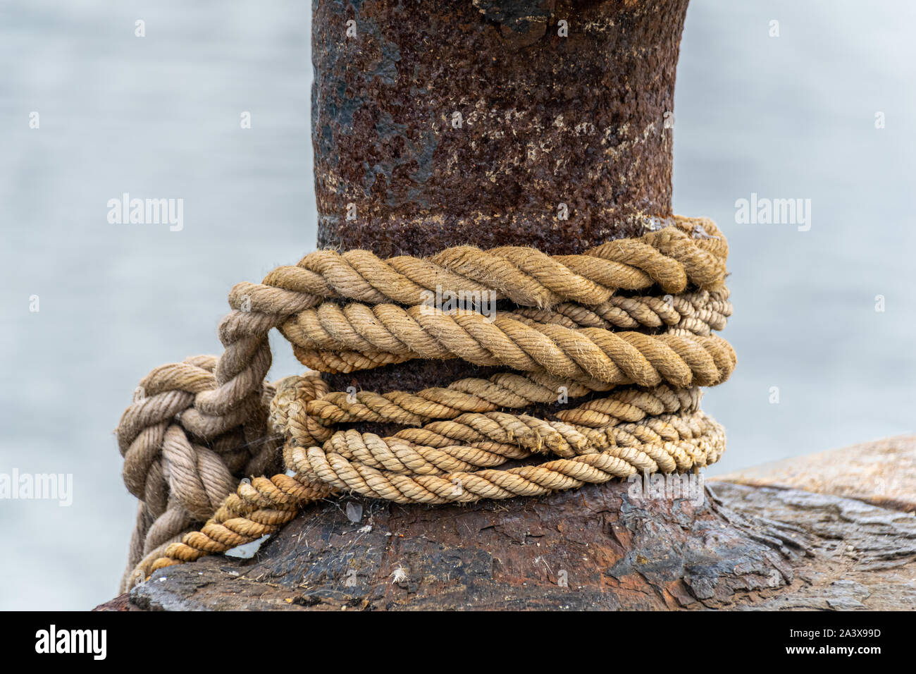 Rope secured around a metal port bollard Stock Photo - Alamy