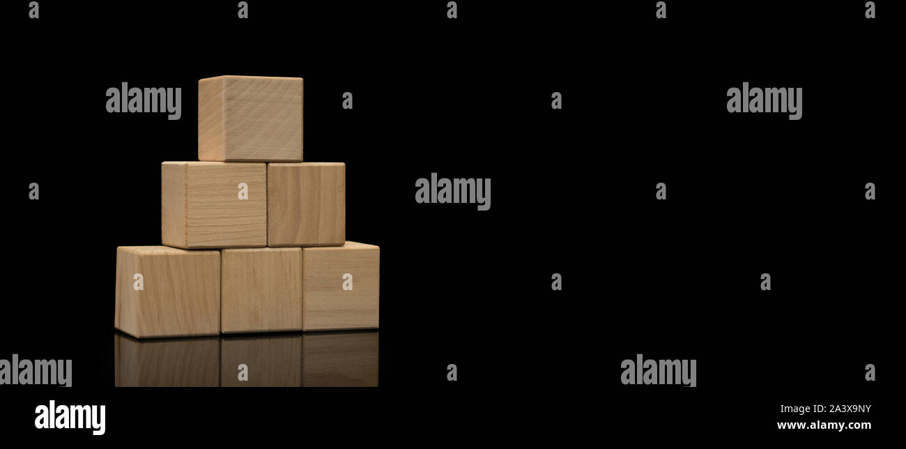 Wood cube arrange in pyramid shape on black background, business ...