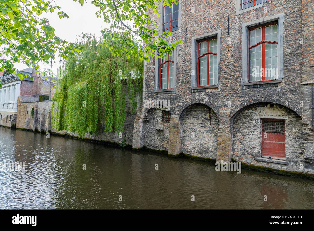 View of Dijver canal with buildings and trees in Bruges, Belgium Stock ...