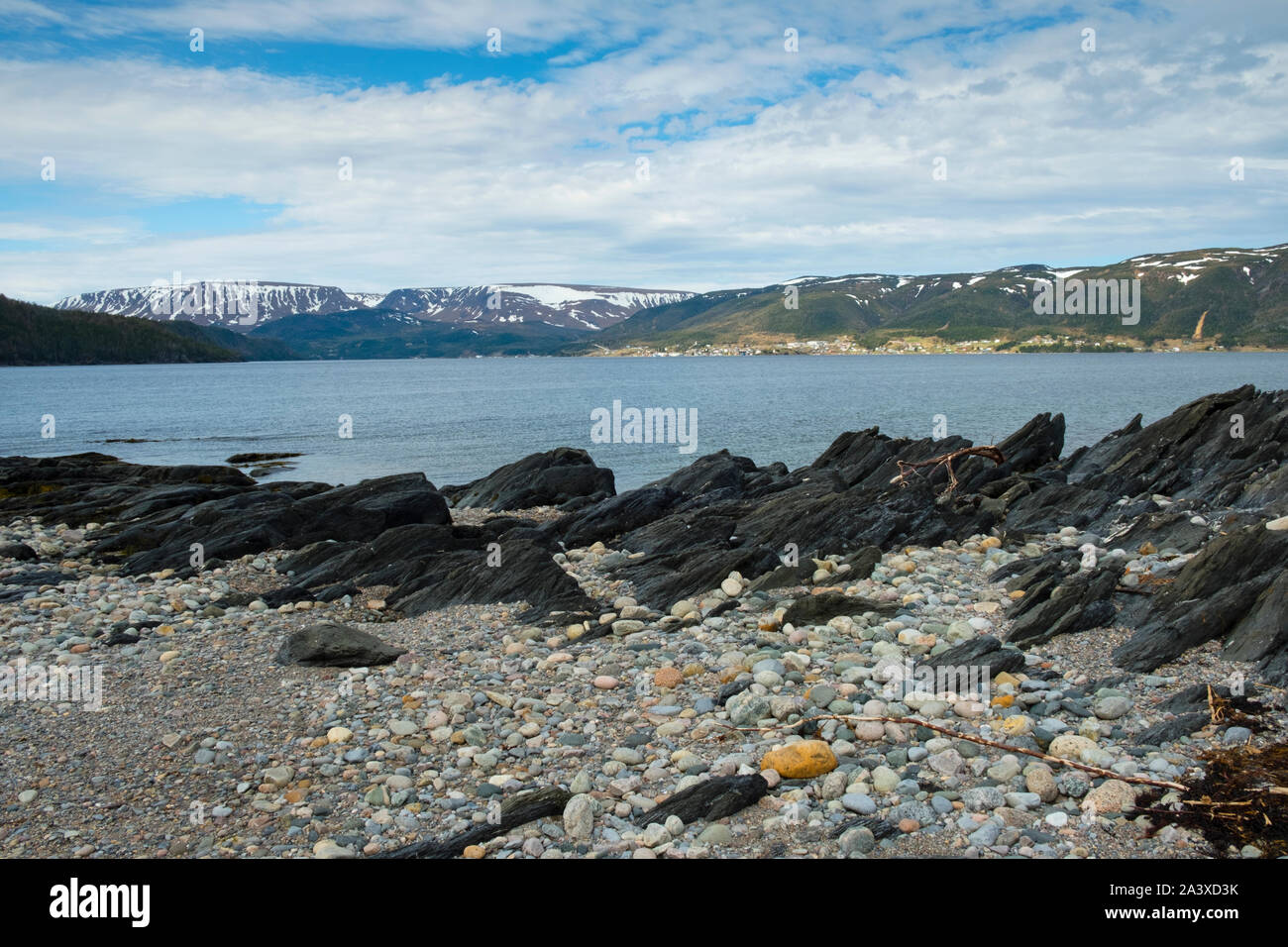 Beach at Norris Point with view across the fjord of the Tablelands and ...
