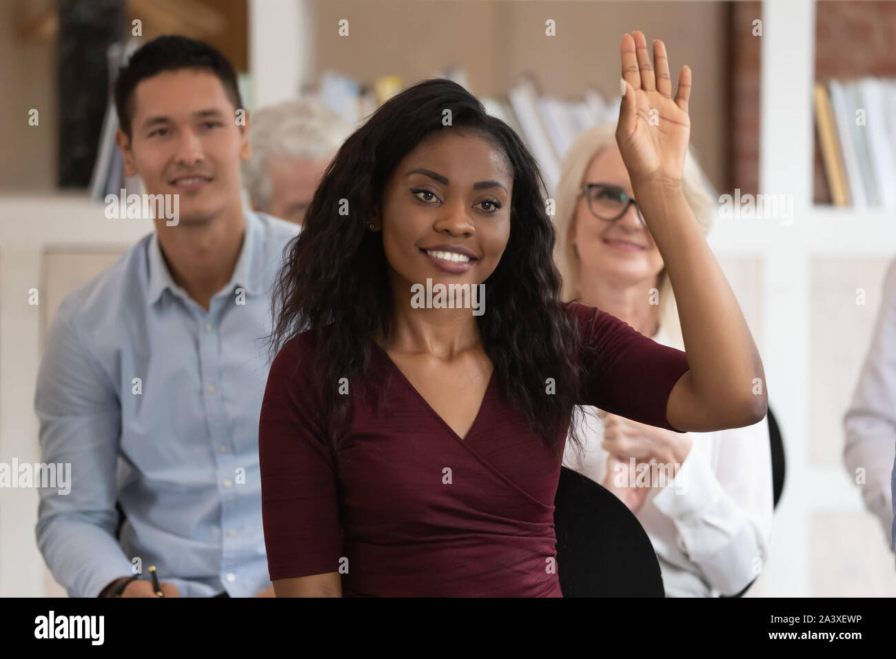 Smiling black female raise hand answering at seminar Stock Photo - Alamy
