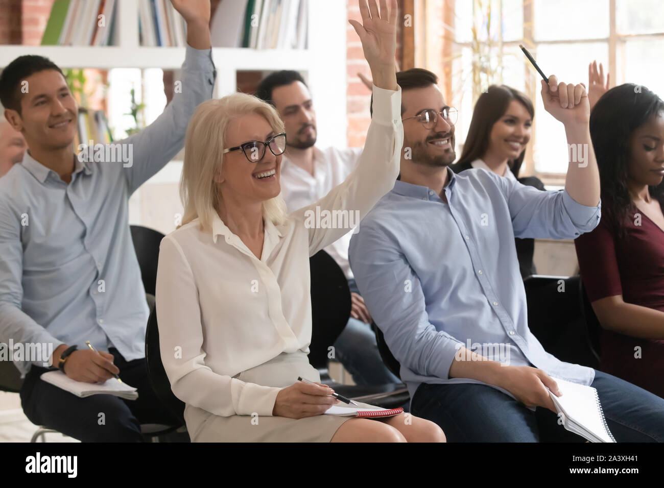 Motivated diverse employees raise hand participating in training Stock ...