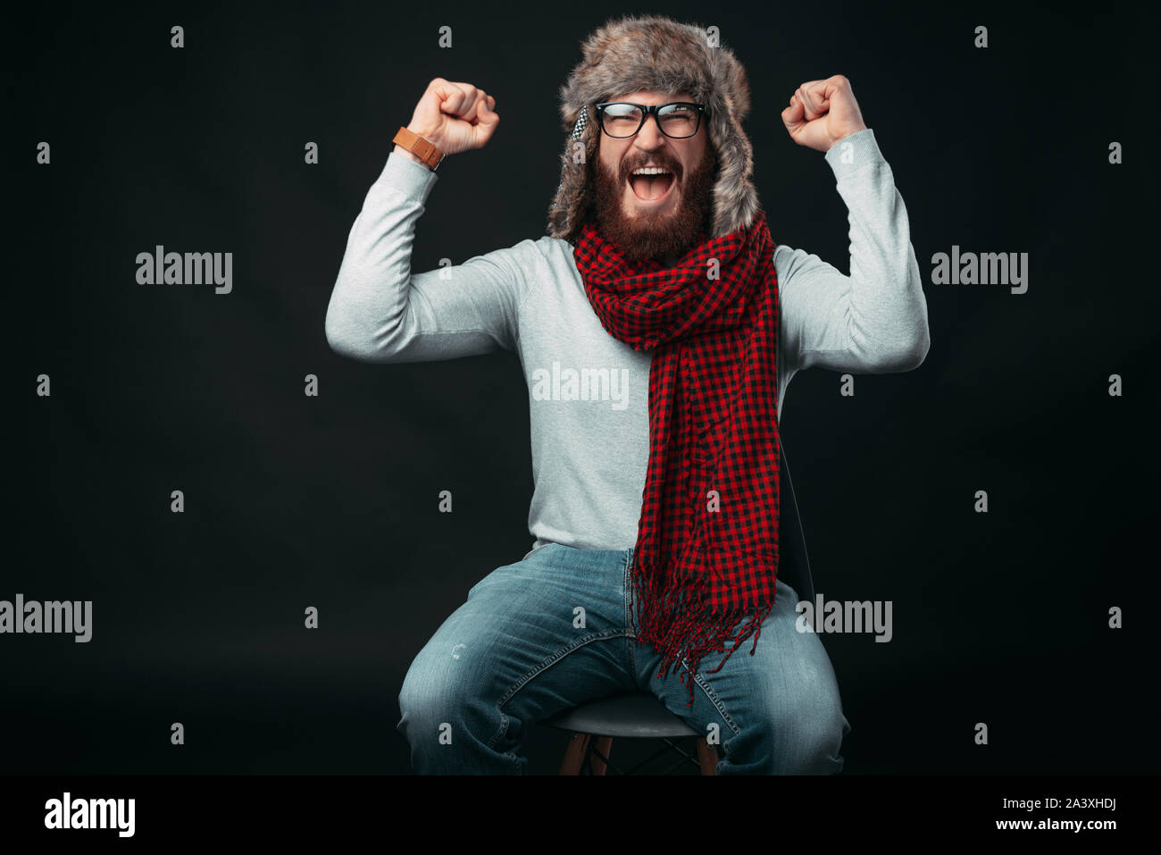 I am a winner. Bearded man screaming and making a win gesture sitting ...