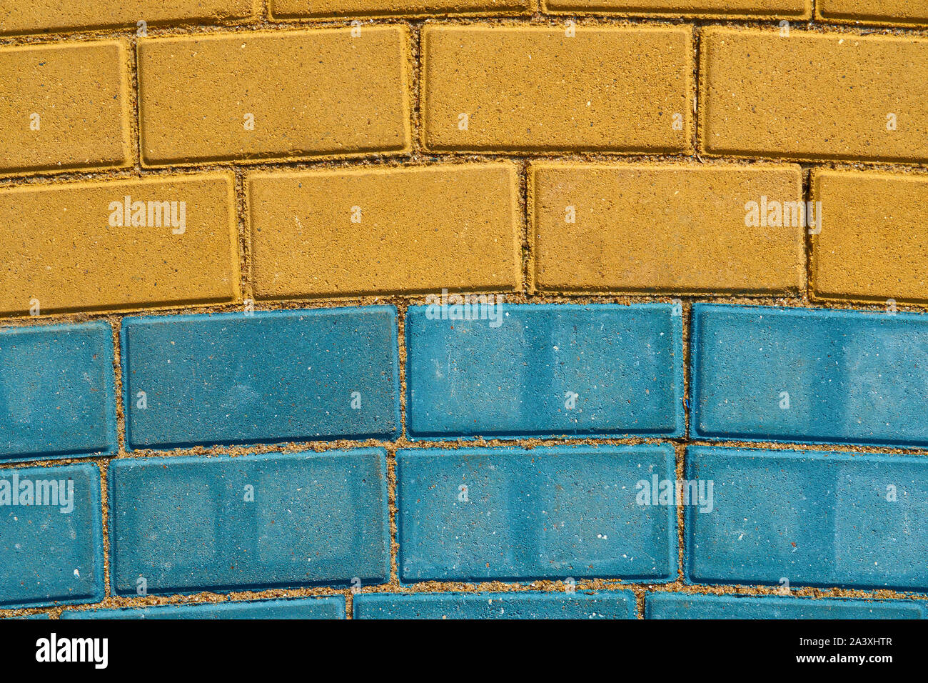 yellow and blue paving tiles for background or texture Stock Photo - Alamy