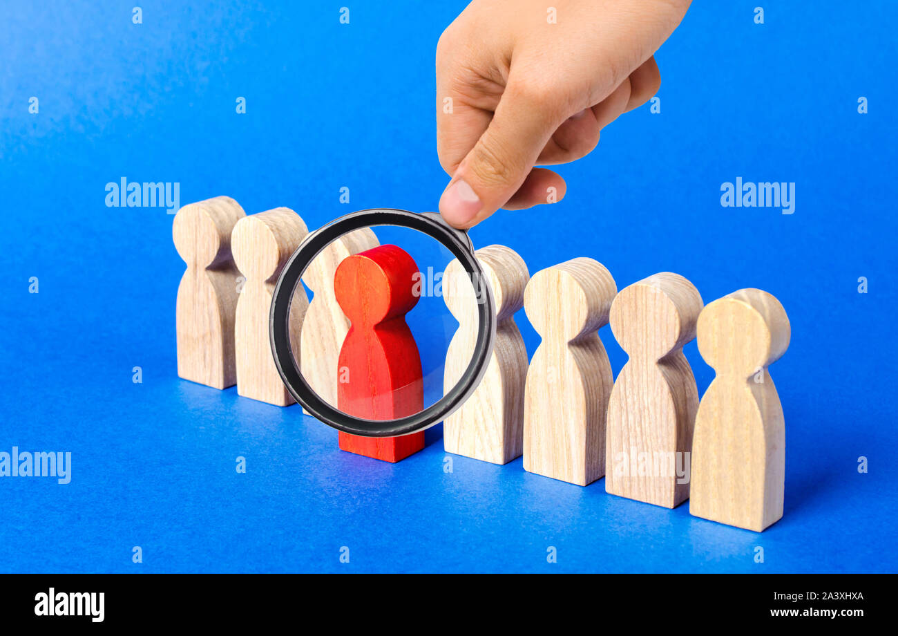 A magnifying glass looks at a red figure person comes out of people ...