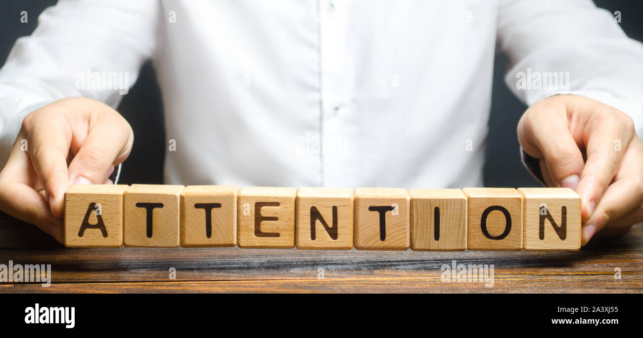 A man holds the word Attention in his hands. Focus on the point. Self ...