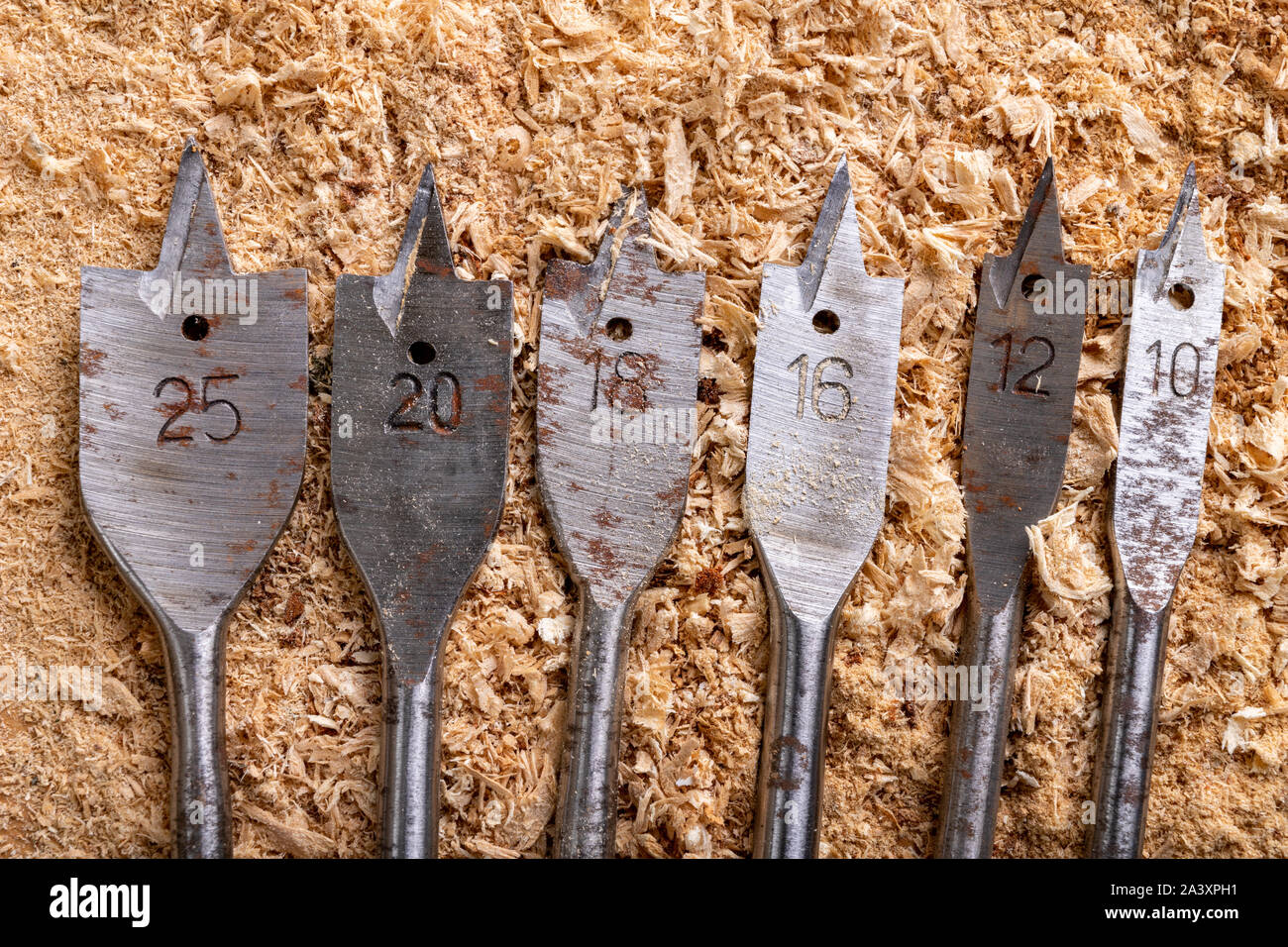 Steel wood drill bits arranged on sawdust. Carpentry accessories for ...