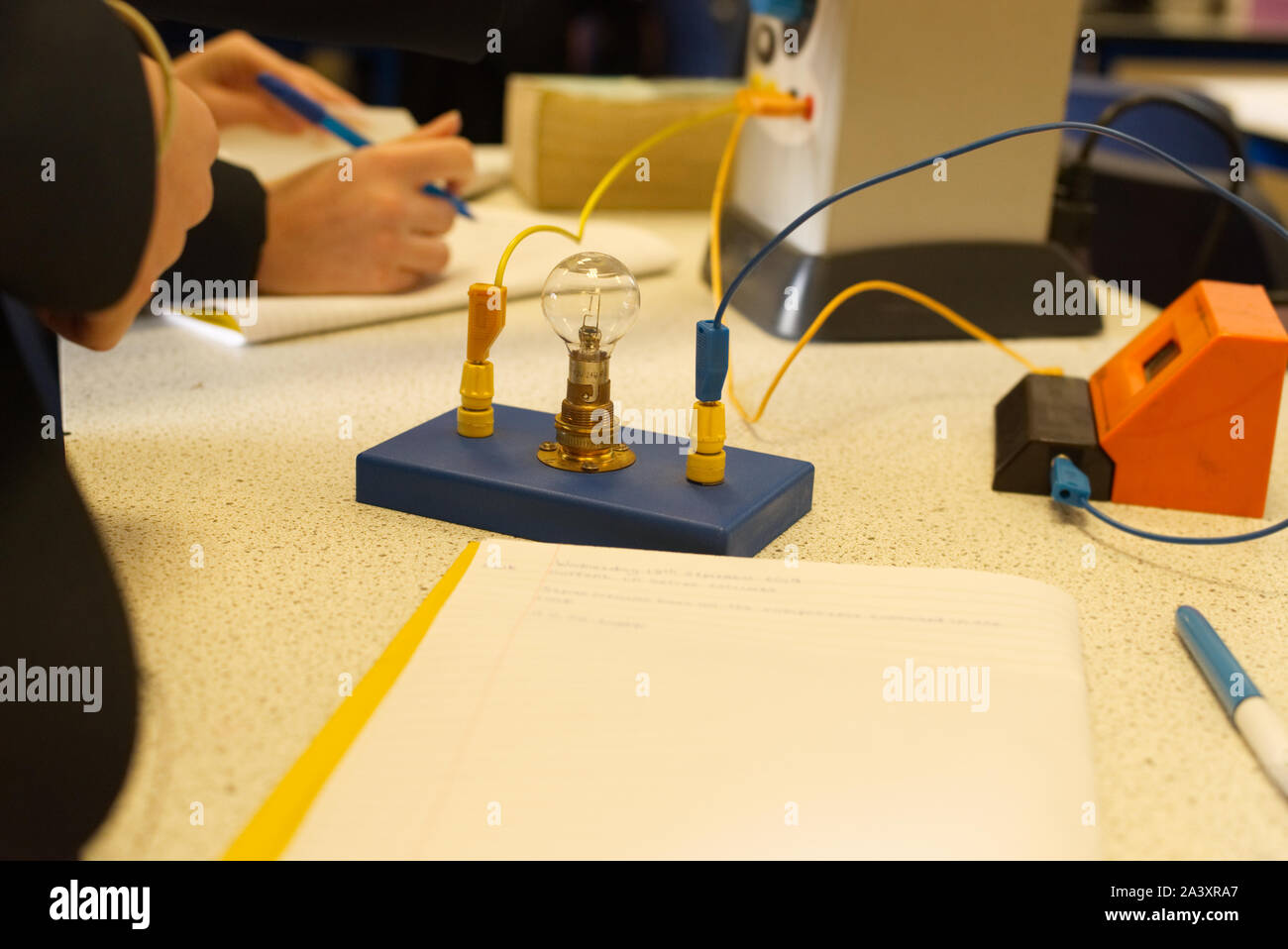 Light bulb in an electric circuit in a school science lab with students ...