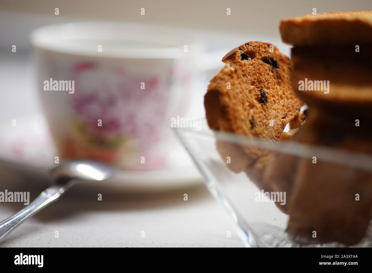 Tea time. Crackers in a glass vase, cup with tea on the blurred ...